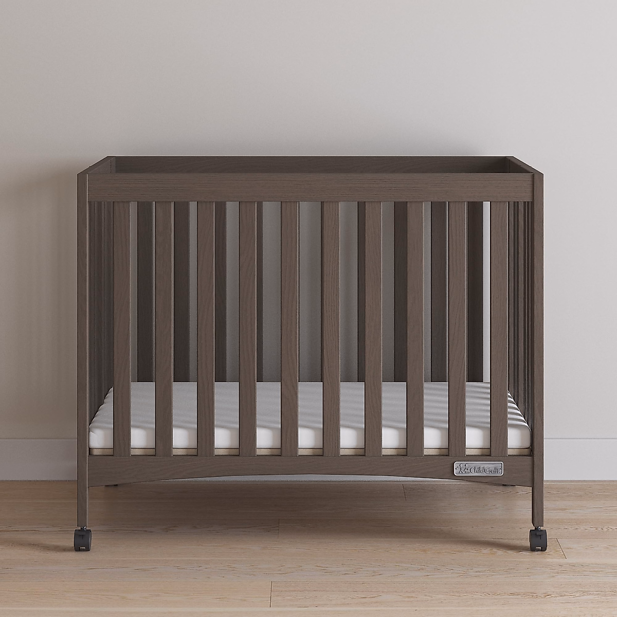 Child Craft London Mini Compact Folding Portable Crib with 2” Crib Mattress and 2 Easy Roll Locking Wheels, Durable Pine Wood Construction (Dapper Gray)