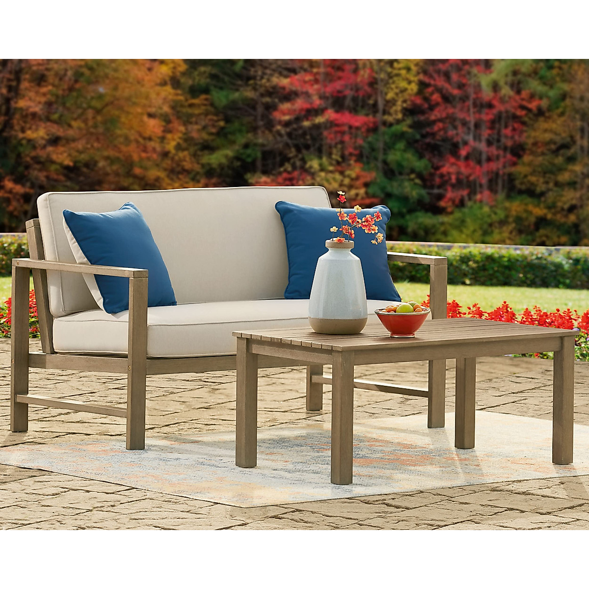 Signature Design by Ashley Outdoor Fynnegan Patio Eucalyptus Loveseat & Coffee Table, Beige with Blue Pillows