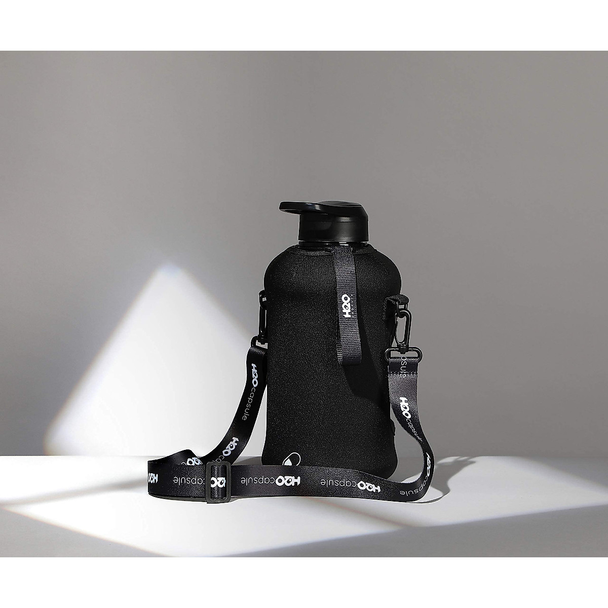 H2O Capsule 2.2L Half Gallon Water Bottle with Storage Sleeve and Covered Straw Lid – BPA Free Large Reusable Drink Container with Handle - Big Sports Jug, 2.2 Liter (74 Ounce) Jet Black