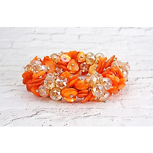 Calisa Designs Woman's orange shell and glass beaded stretch bracelet with silver beads, Designed with clusters of orange shell and orange facet cut glass beads.