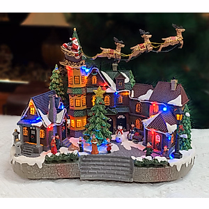 Christmas Village Centerpiece Decor, Santa Riding Sleigh Flying Over The Town Center, with Christmas Tree, featuring LED Lights, Christmas Music, and Animation - Power Adapter (included)