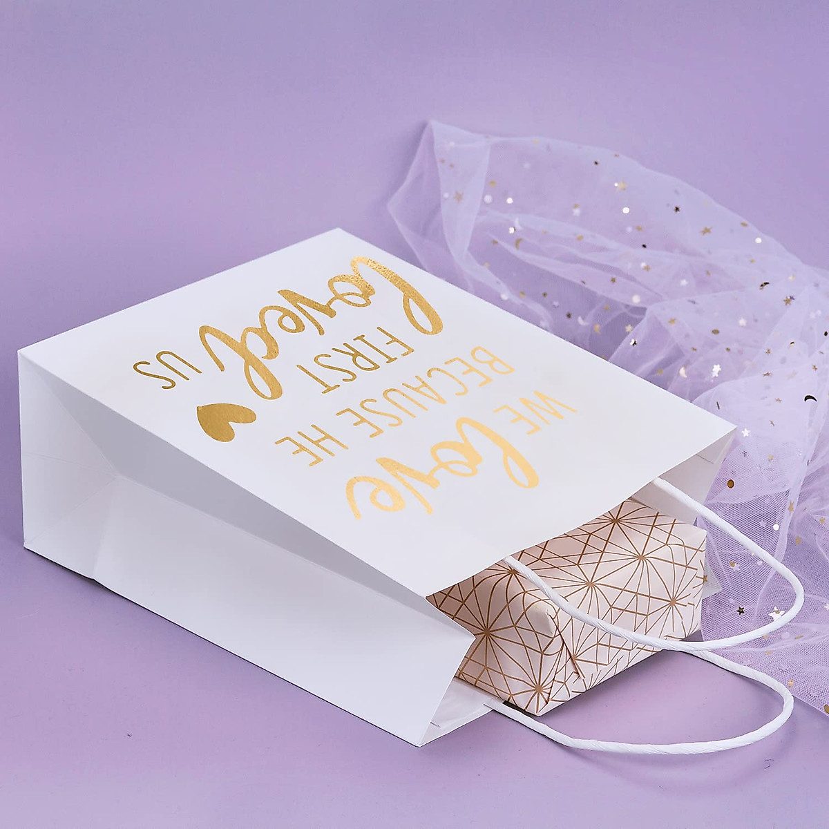 WRAPAHOLIC Medium Size Gift Bags - Gold Foil We Love Because He First Loved Us White Paper Bags with Handles for the Lovers of Scriptures and Christians - 12 Pack - 8" x 4" x 10"