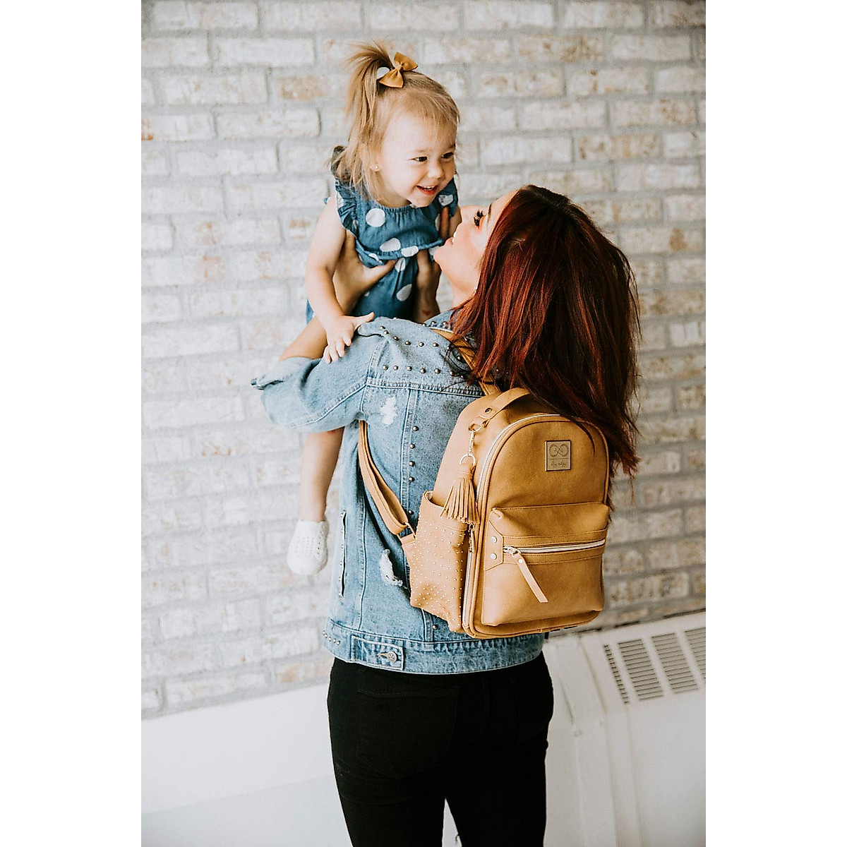 Itzy Ritzy Chelsea + Cole Mini Diaper Bag Backpack - Studded Mini Backpack with Changing Pad, 8 Pockets, Rubber Feet & Tassel - Caramel with Sweetheart Print Interior and Gold Hardware