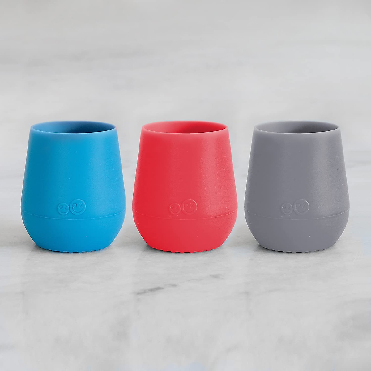 ezpz Tiny Cup 3-Pack (Blue, Coral & Gray) - 100% Silicone Training Cup for Infants - Designed by a Pediatric Feeding Specialist - 4 months+ - Baby-led Weaning Gear & Baby Gift