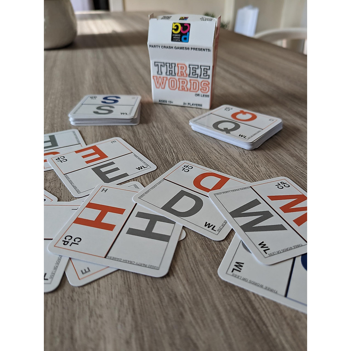 PARTY CRASH GAMES Presents: THREE WORDS OR LESS - A Simple, Yet Challenging Little Word Game; Designed for 2-6 Players 13+ Who are A Clever Wordsmith... 3 WORDS OR LESS