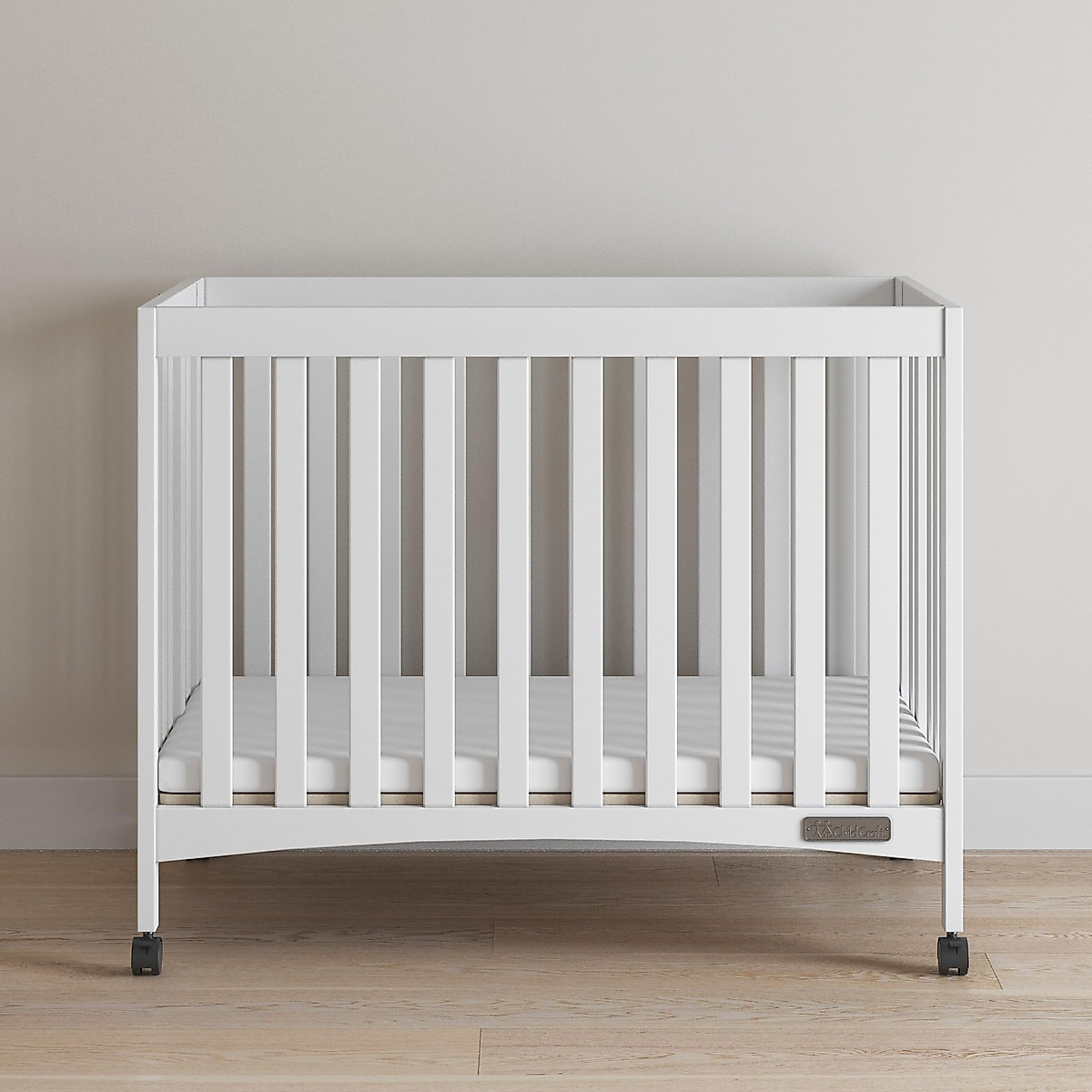 Child Craft London Mini Compact Folding Portable Crib with 2” Crib Mattress and 2 Easy Roll Locking Wheels, Durable Pine Wood Construction (Matte White)