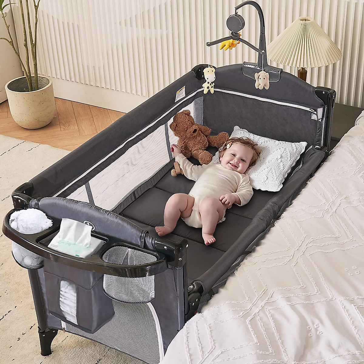 MOOITZ Baby Bassinet Bedside Crib, 6-in-1 Pack and Play with Bassinet, 4 Height Adjustable Bedside Crib, Newborn Portable Bassinet with Wheels, U-Shaped Diaper Table, Music Box & Hanging Toys