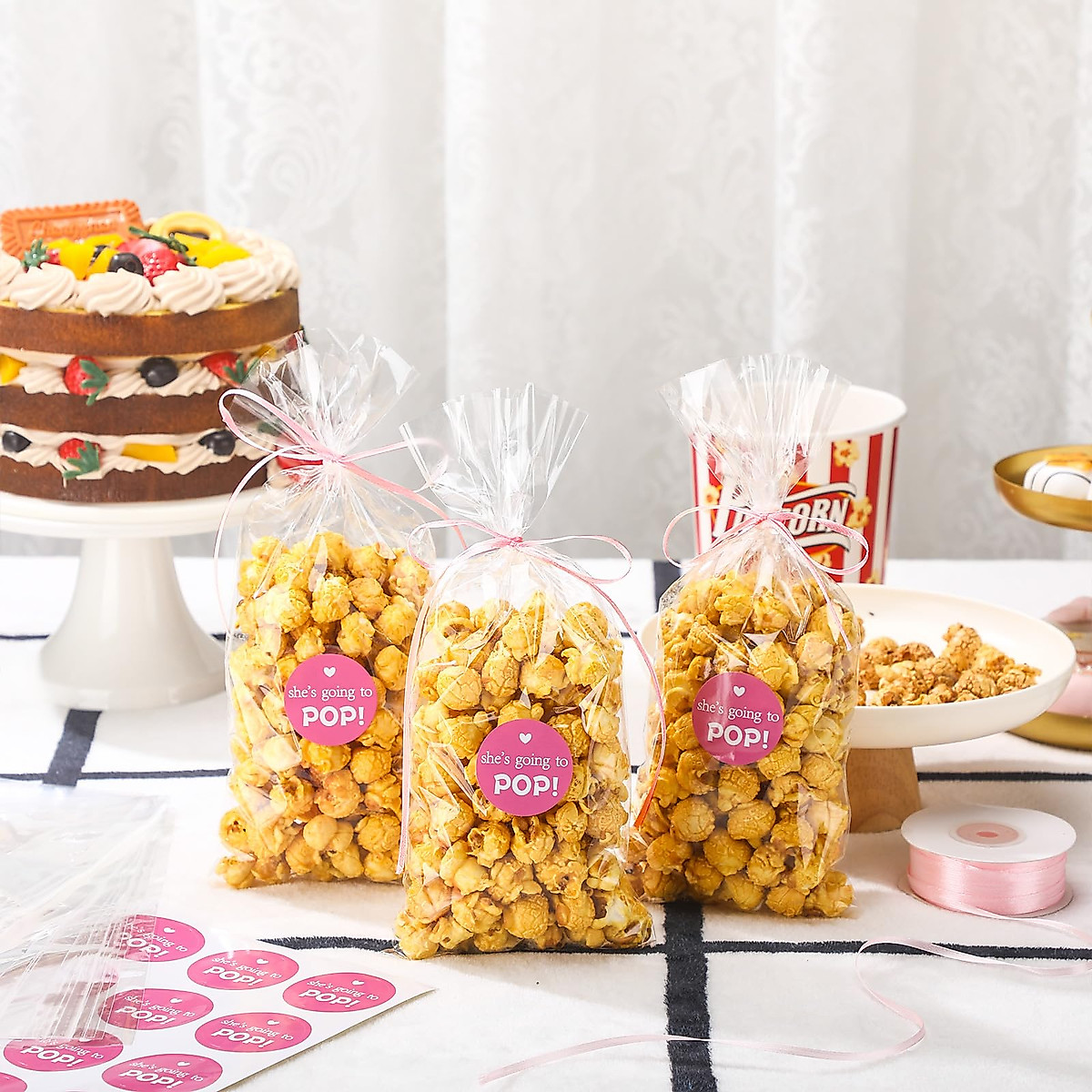 Menkxi 100 Pack Clear Popcorn Bags Bulk 4.92 x 10.83 Inch Cellophane Treat Bags with She Is Going to Pop Label and Ribbon Plastic Popcorn Bags for Gift Wrapping, Food Storage, Baby Shower Decor(Pink)