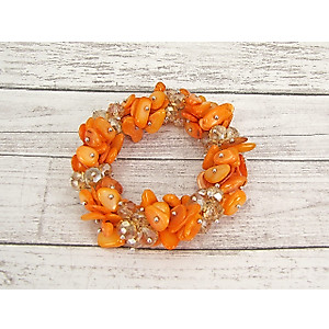 Calisa Designs Woman's orange shell and glass beaded stretch bracelet with silver beads, Designed with clusters of orange shell and orange facet cut glass beads.
