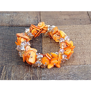 Calisa Designs Woman's orange shell and glass beaded stretch bracelet with silver beads, Designed with clusters of orange shell and orange facet cut glass beads.