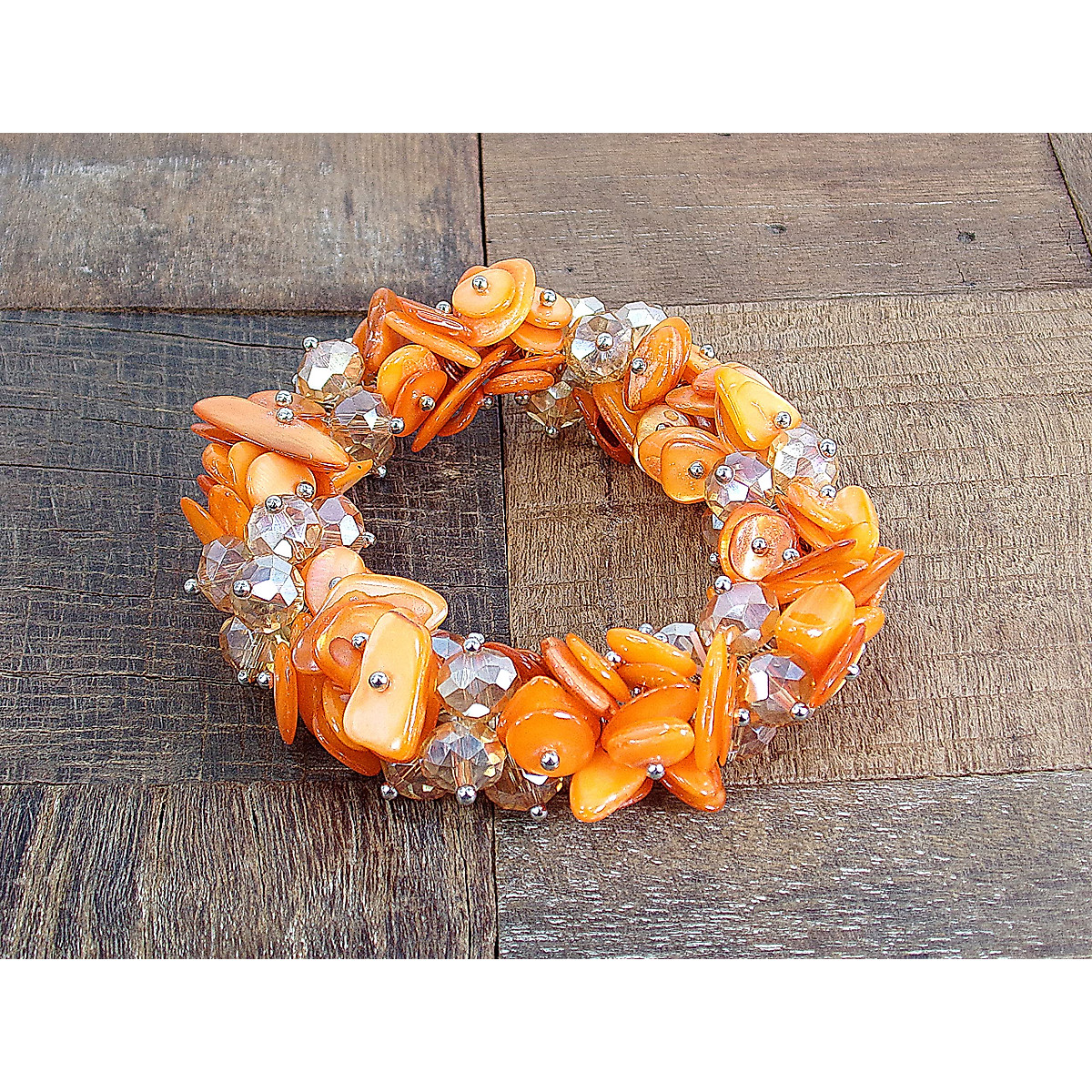 Calisa Designs Woman's orange shell and glass beaded stretch bracelet with silver beads, Designed with clusters of orange shell and orange facet cut glass beads.