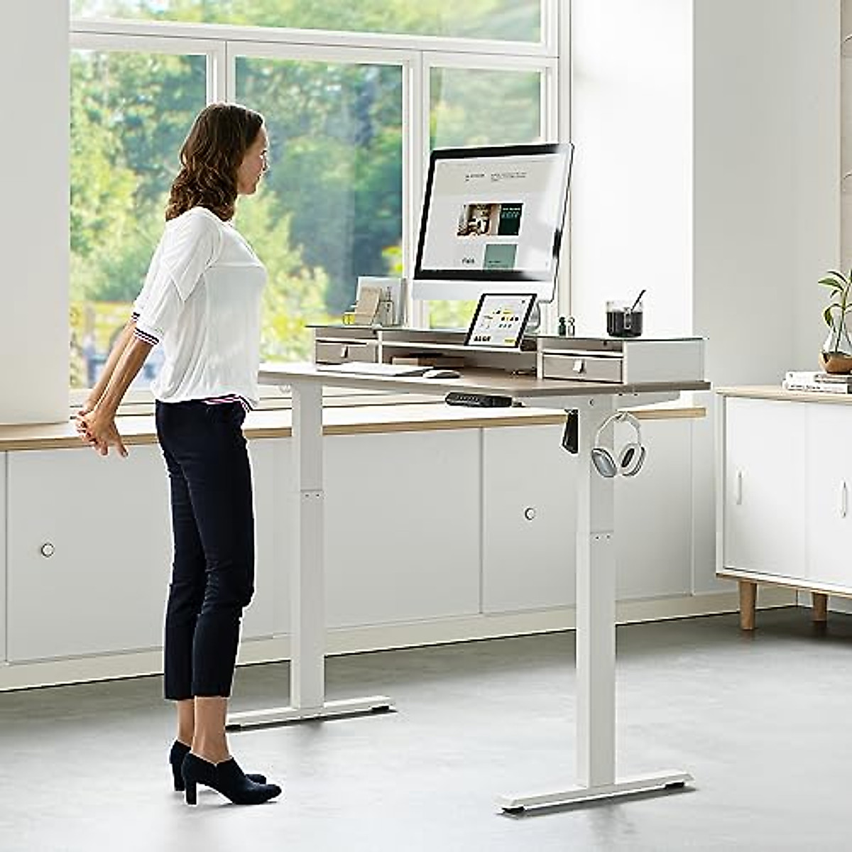 FEZIBO Electric Standing Desk with Double Drawers, 48 x 24 Inch Glass Top Monitor Stand Adjustable Sit Stand Desk with Storage Shelf, White Frame/LightWalnut Top