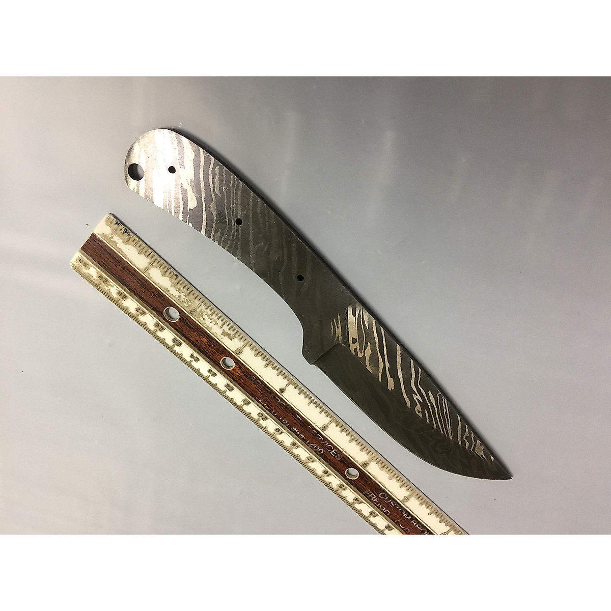 8.5 inches long hand forged Twist pattern Damascus steel trailing point blank blade skinning knife with 3 Pin hole & an inserting hole space 4 inches cutting edge