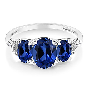 Gem Stone King 10K White Gold Oval Blue Created Sapphire and Diamond Accent 3-Stone Women Engagement Ring (2.65 Cttw) (Size 5)