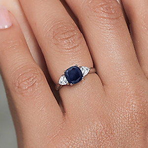 Gem Stone King 10K White Gold Blue Sapphire and White Moissanite Engagement Ring | 2.46 Cttw | 7MM Cushion and 4MM Trillion | 3 Stone Wedding Engagement Anniversary Promise Ring For Women (Size 6)