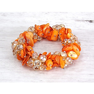 Calisa Designs Woman's orange shell and glass beaded stretch bracelet with silver beads, Designed with clusters of orange shell and orange facet cut glass beads.