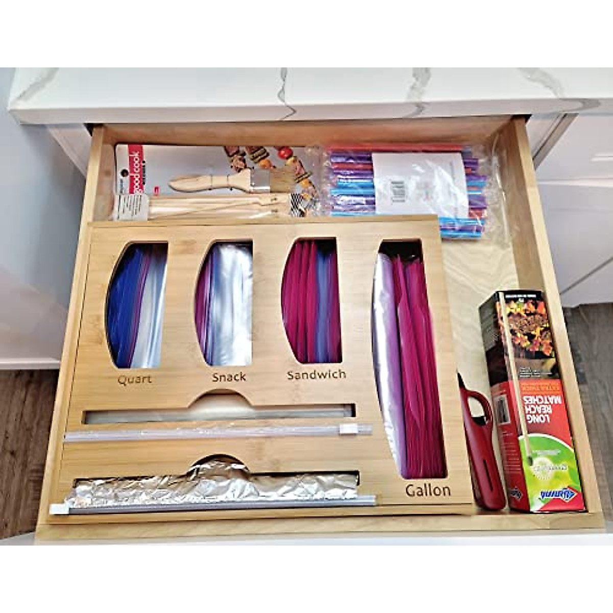 Redesigned and OVERSIZED ZipLock Bag storage organizer with plastic wrap and aluminum foil dispenser with cutter. 4 slots - Quart, Sandwich, Freezer and Gallon size.