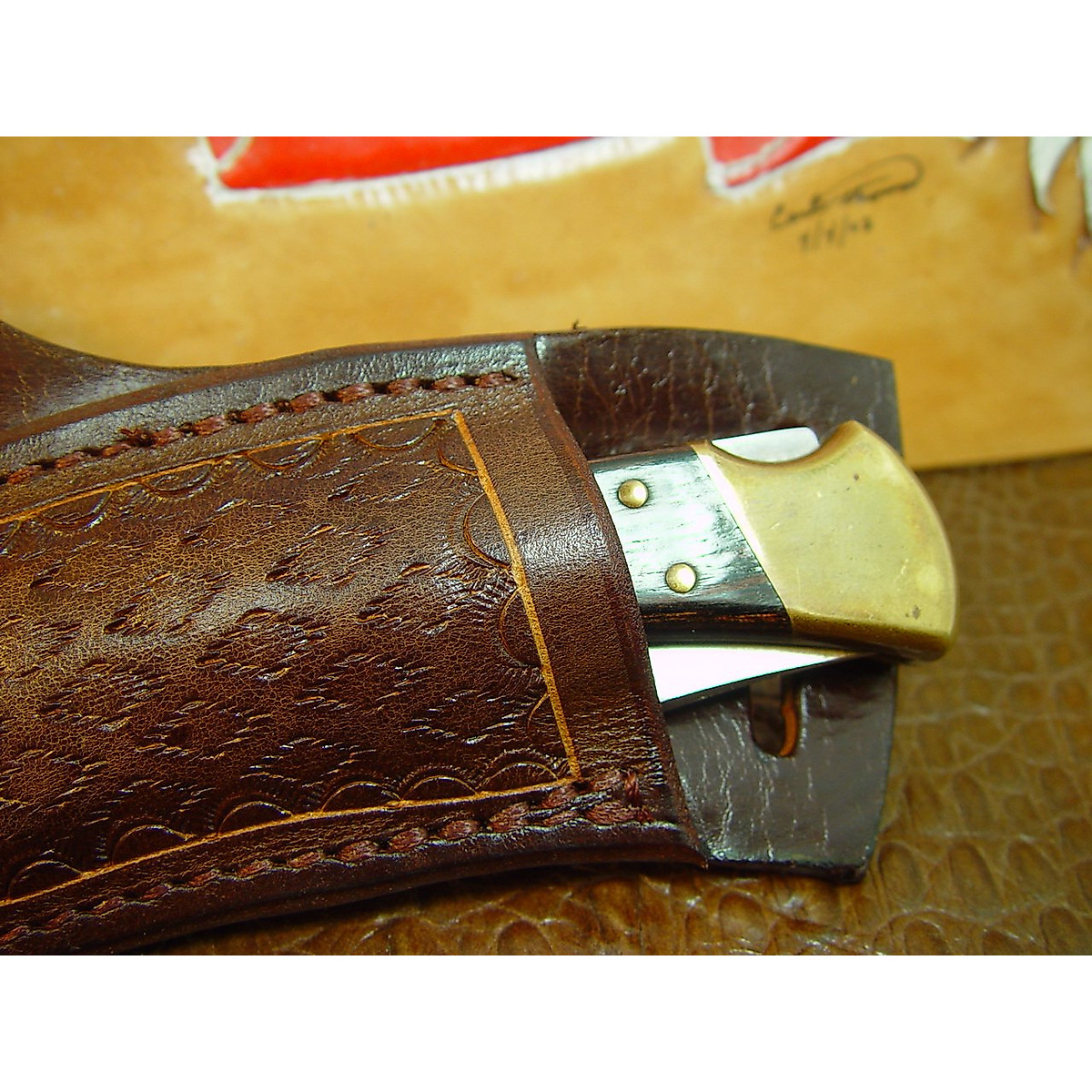 Custom left hand cross draw knife sheath for a buck 110 knife. The sheath is made out of buffalo hide leather hand tooled with a basket weave pattern.