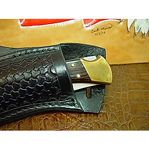 Buck Custom Left Hand Cross Draw Knife Sheath for a 110 Knife. The Sheath is Made Out of Buffalo Hide Leather Hand Tooled with a Basket Weave Pattern.